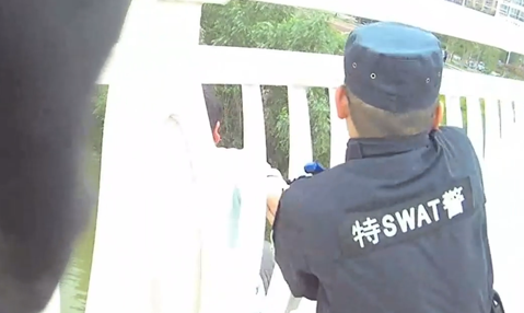 男子跨过大桥栏杆欲跳河轻生生死时刻周口特警飞身过去一把将人拽住